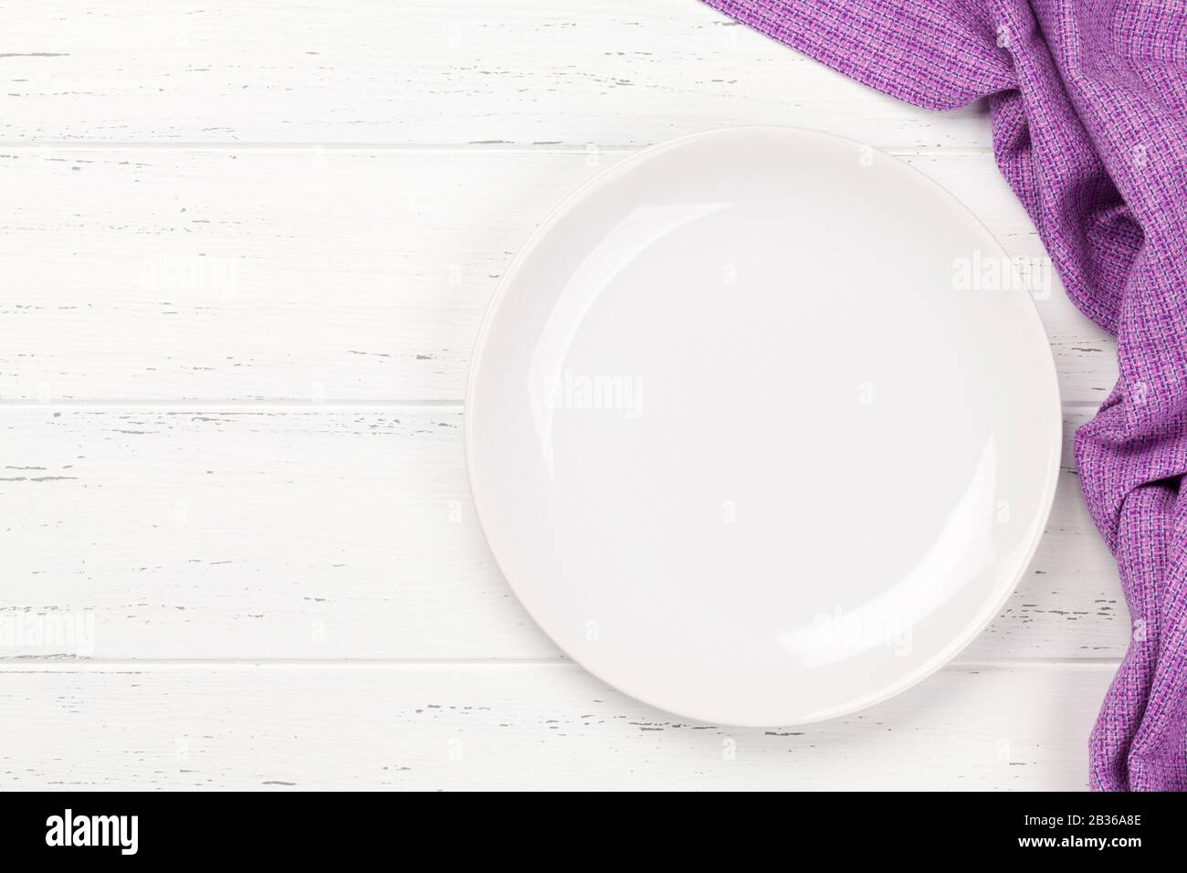 Kitchen table with empty plate, tablecloth and space for your recipe or ...