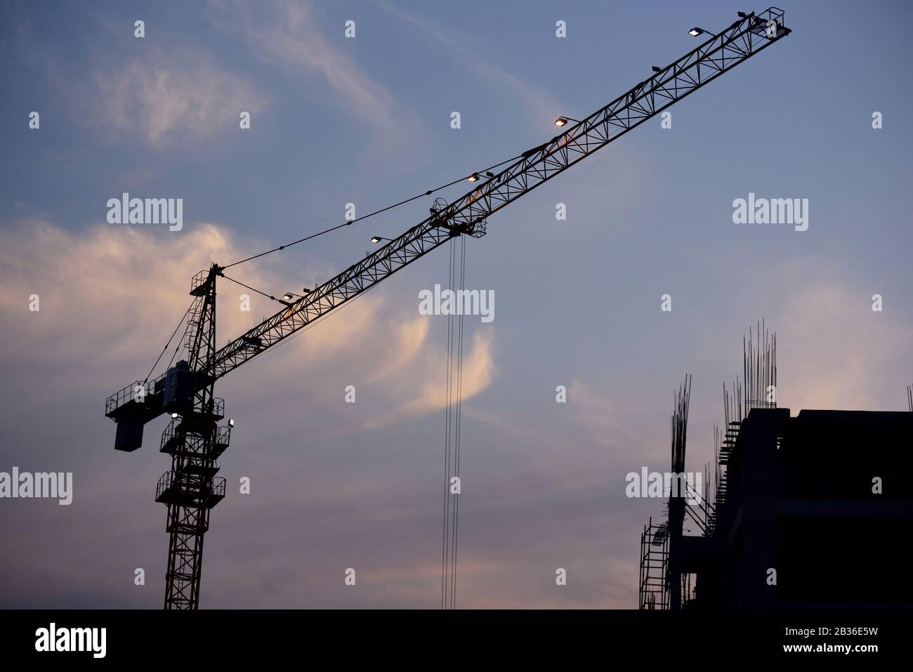 Construction building with crane over sunset time Stock Photo - Alamy