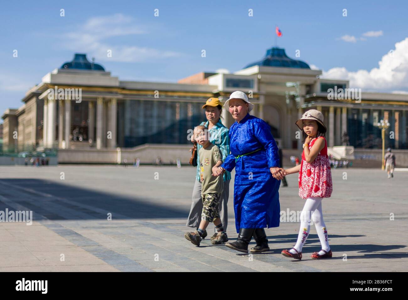 Mongolia, Ulan Bator, Mongolian family walking in front of the Government Palace on Chingis ...