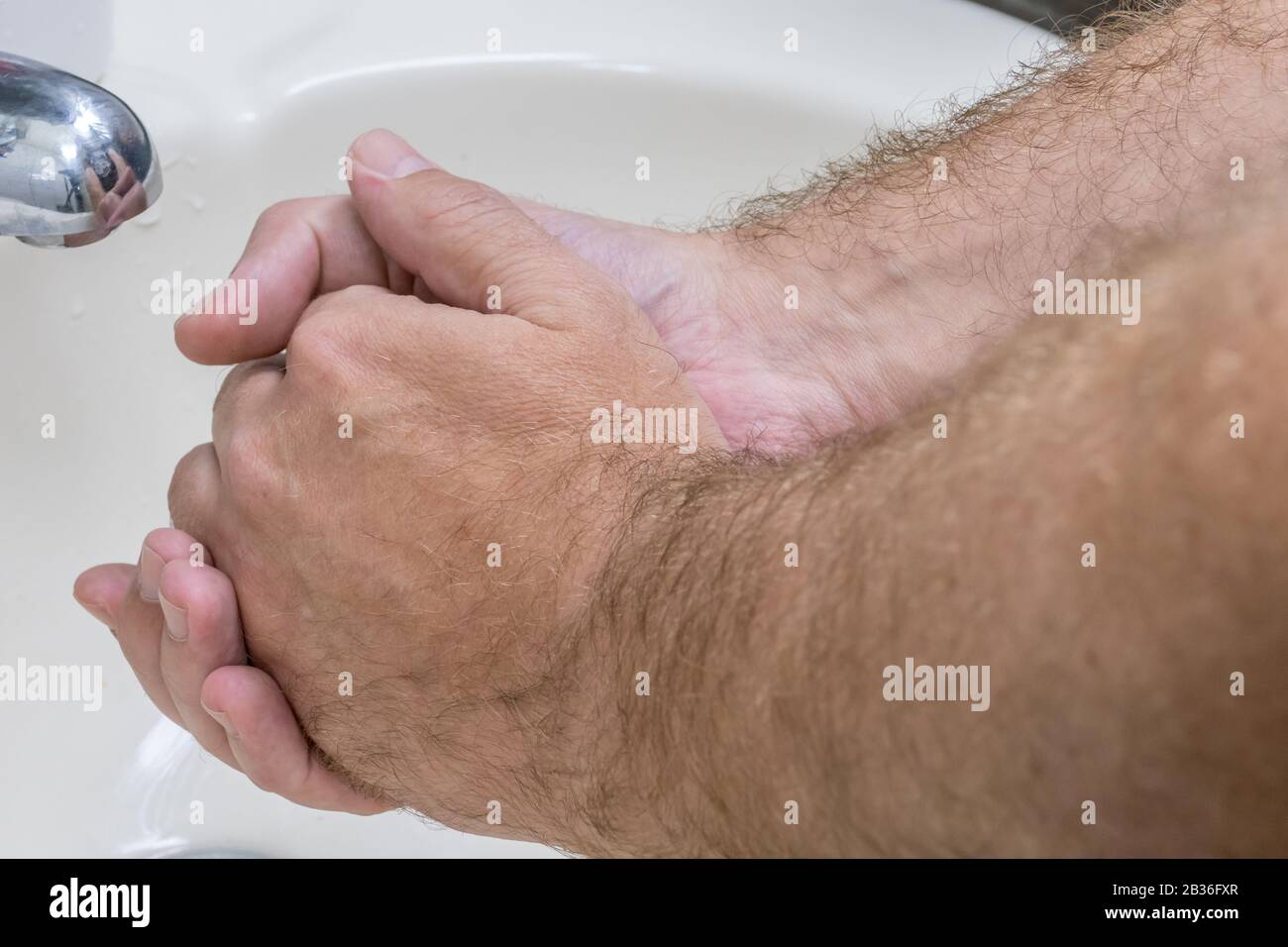 Man washing hands in basin close-up, one of several in handwashing ...