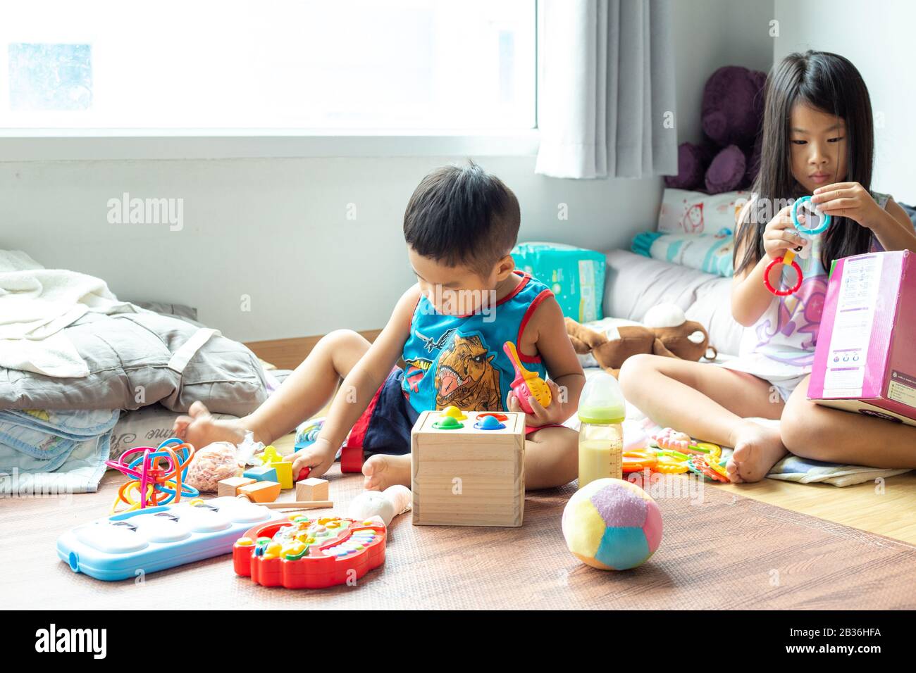 Group of children playing together with wooden toy box learning ...