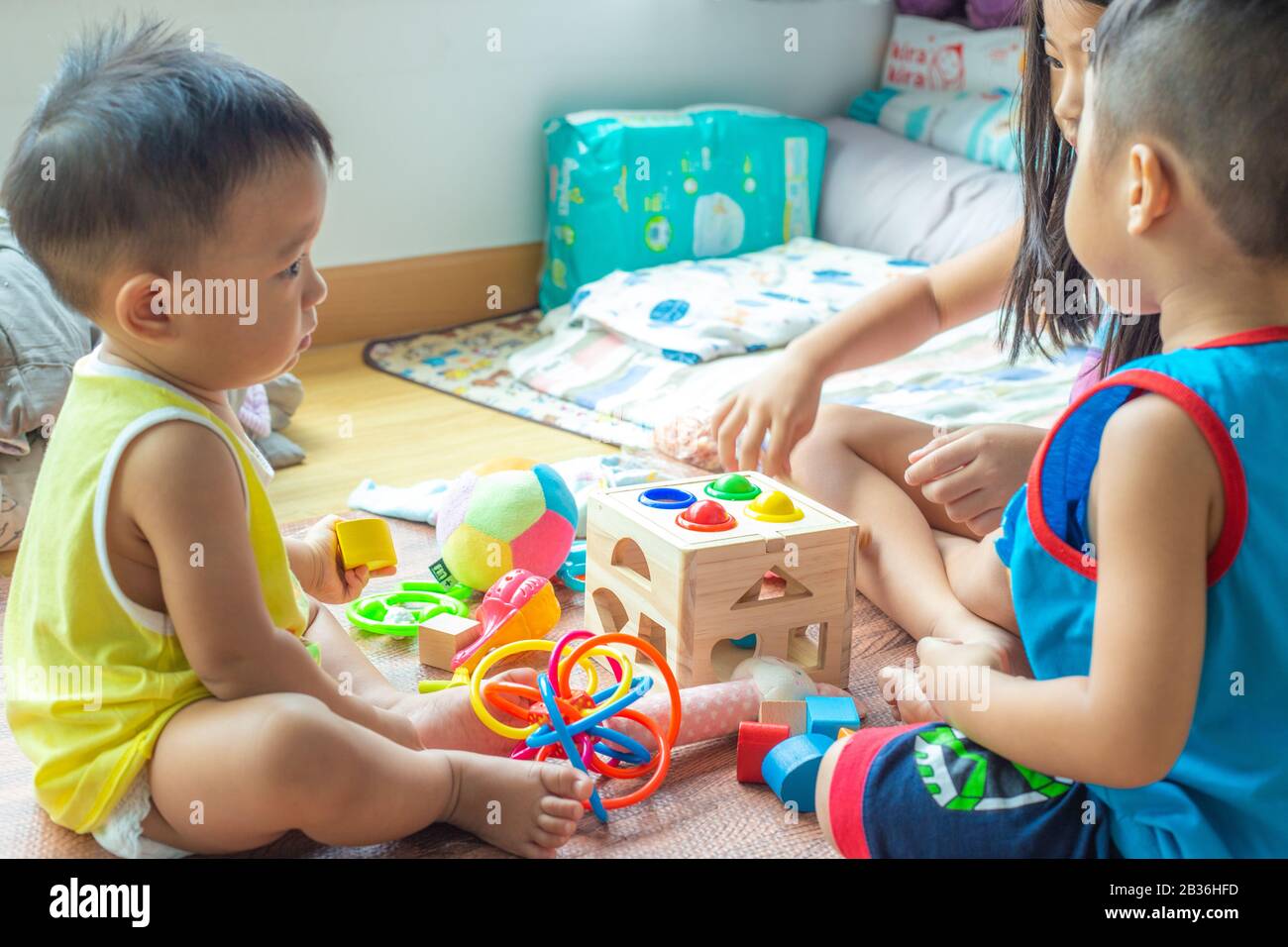 Group of children playing together with wooden toy box learning ...