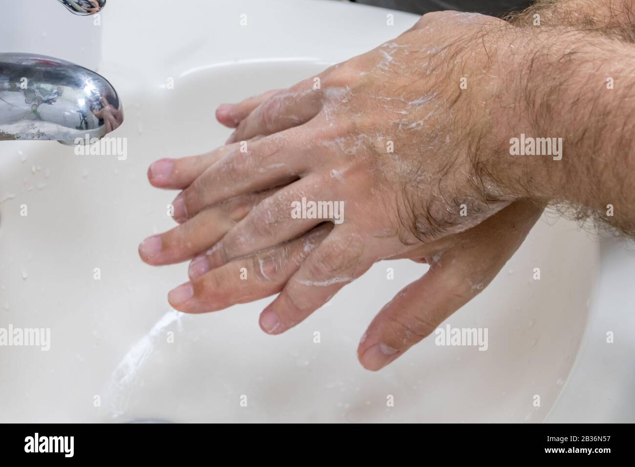 Man washing hands in basin close-up, one of several in handwashing ...