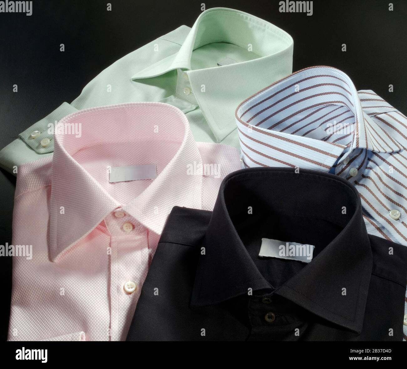 four men's shirts on black background Stock Photo - Alamy