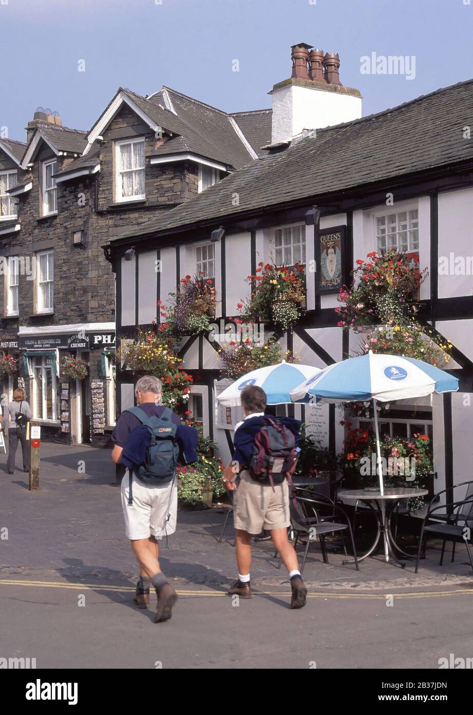 Walkers in Main Street Hawkshead village popular Lake District tourist ...