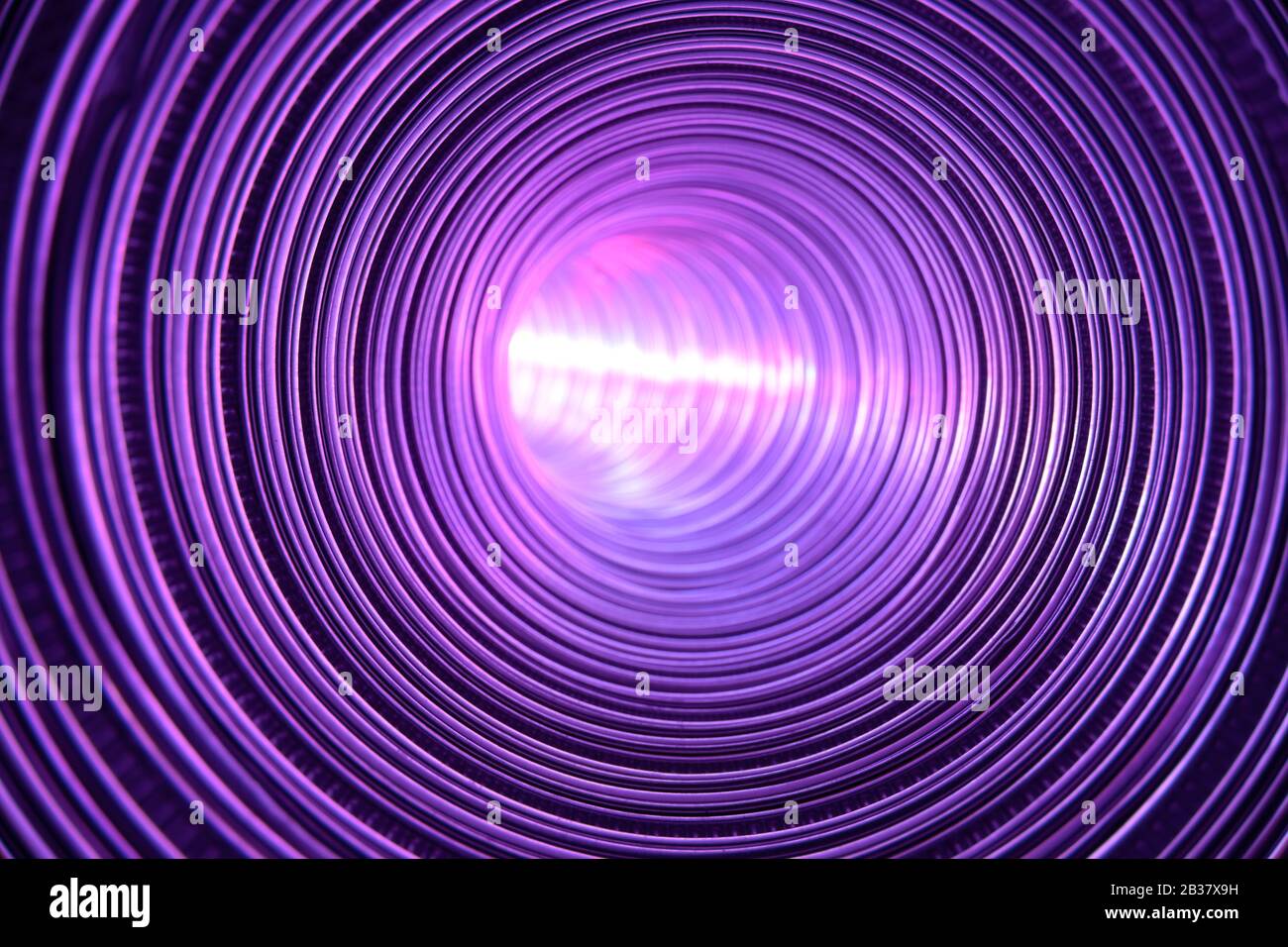 Futuristic metallic circular corridor illuminated by purple light ...