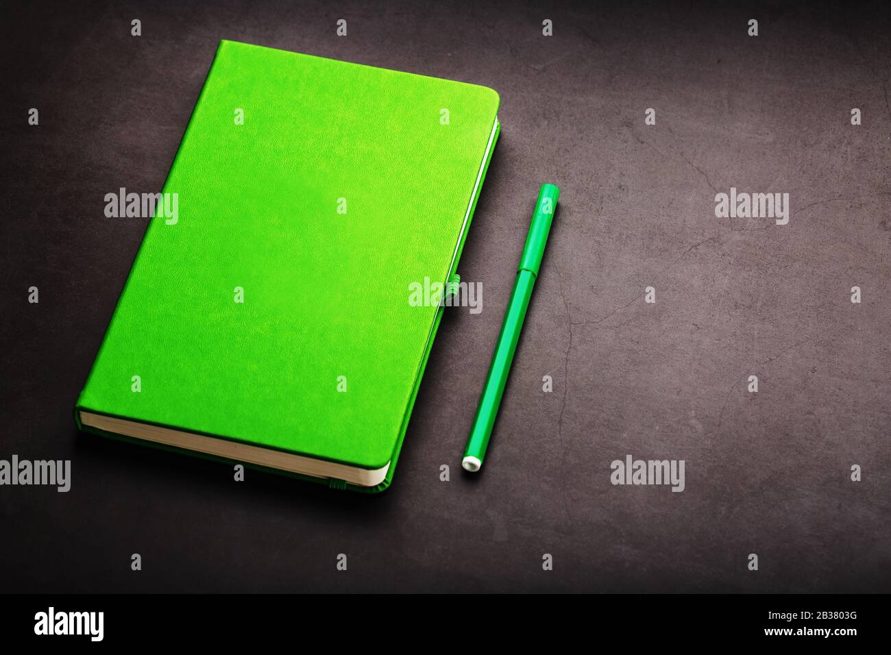 Green Notepad with a felt-tip pen on a black background, top view. Free ...