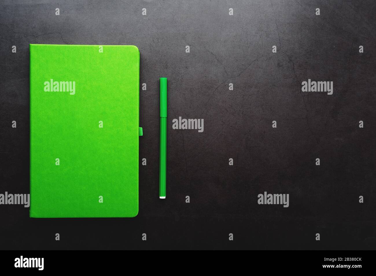 Green Notepad with a felt-tip pen on a black background, top view. Free ...