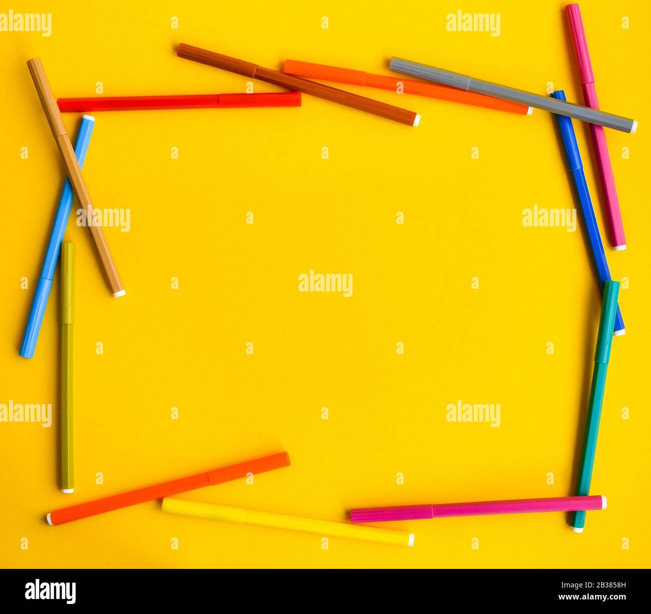 Felt-tip pens on a yellow background with copy space, set of new bright ...