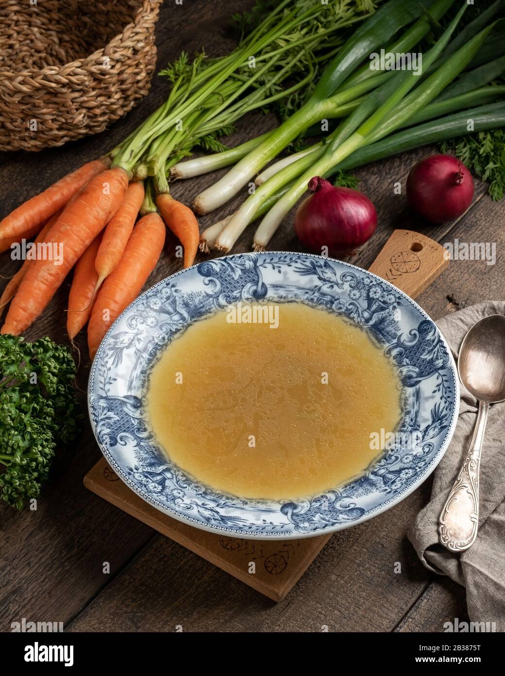 Chicken bone broth in a plate and fresh vegetables Stock Photo - Alamy
