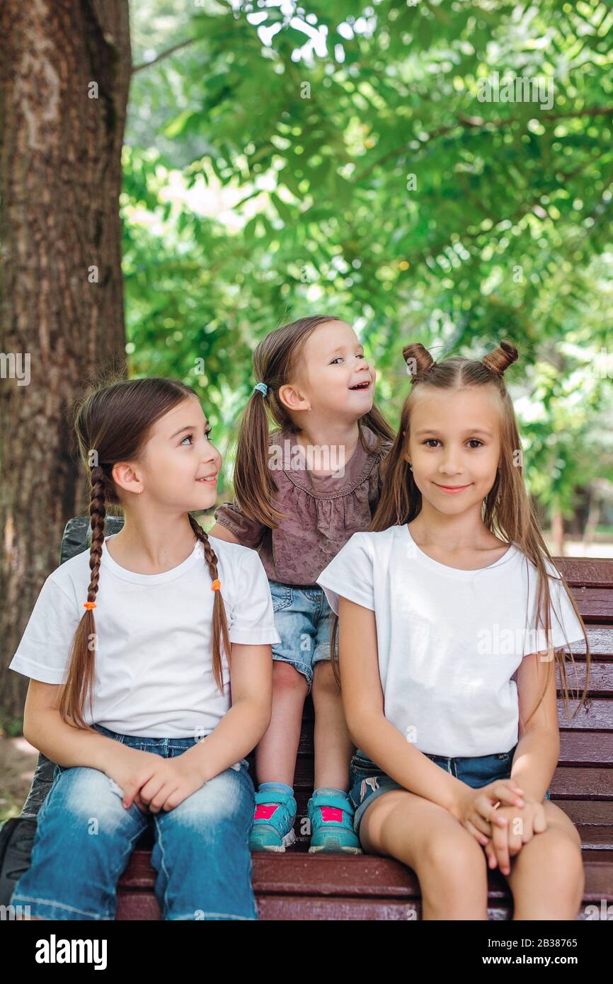 Three sisters smiling and hugging outdoors in summer park Stock Photo ...