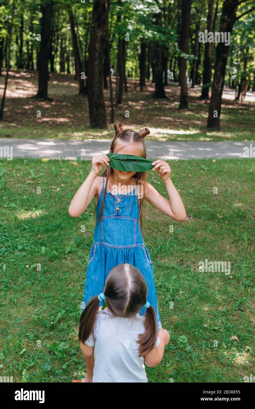 Funny active kids playing on green grass in spring park Stock Photo - Alamy