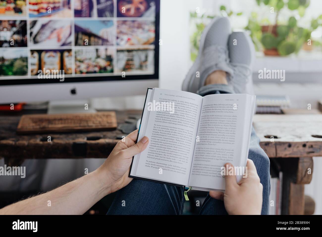 Man is reading book & looking at display with photos Stock Photo - Alamy