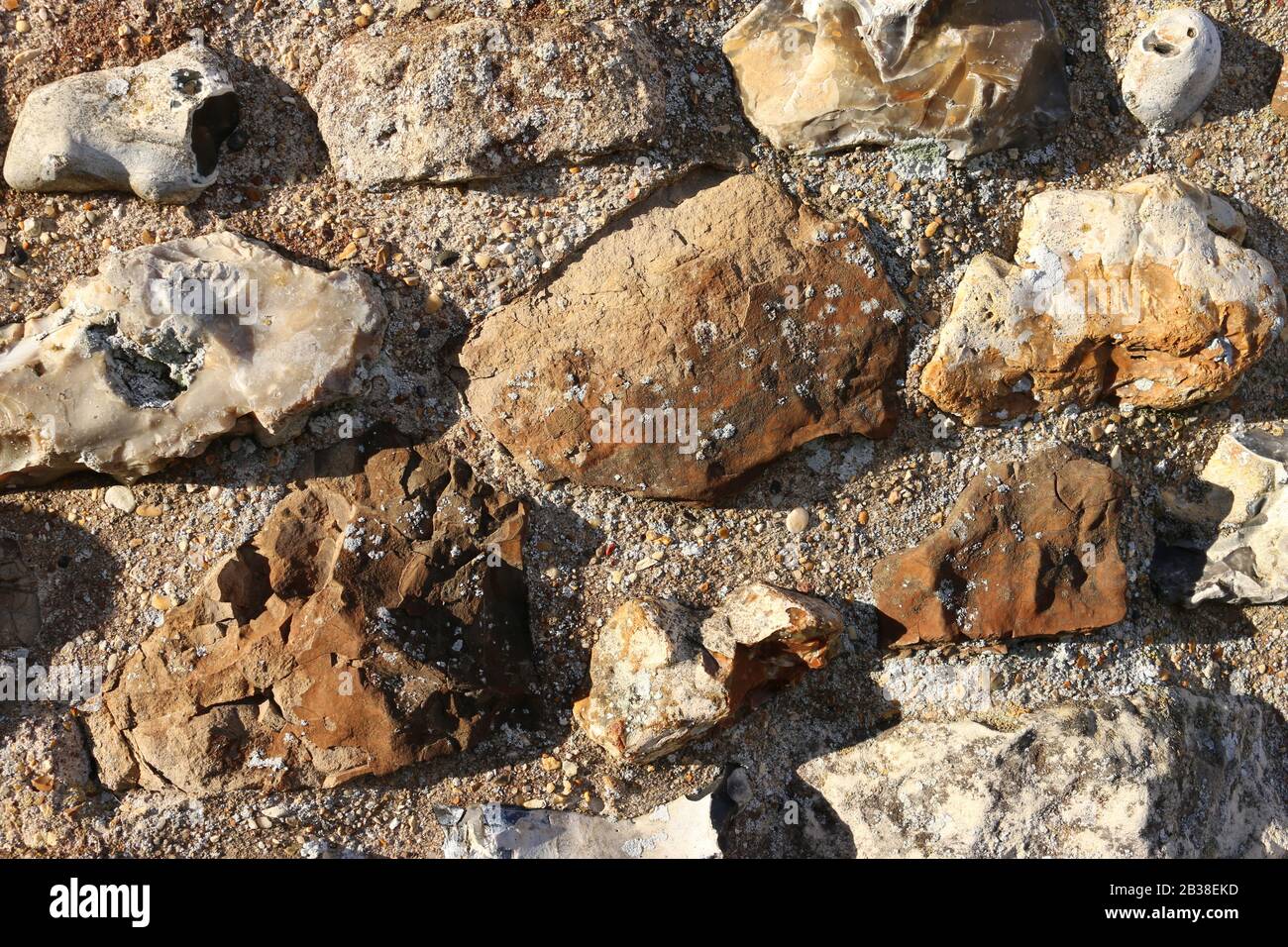 Old medieval castle wall in close up with flints and other stone set in ...