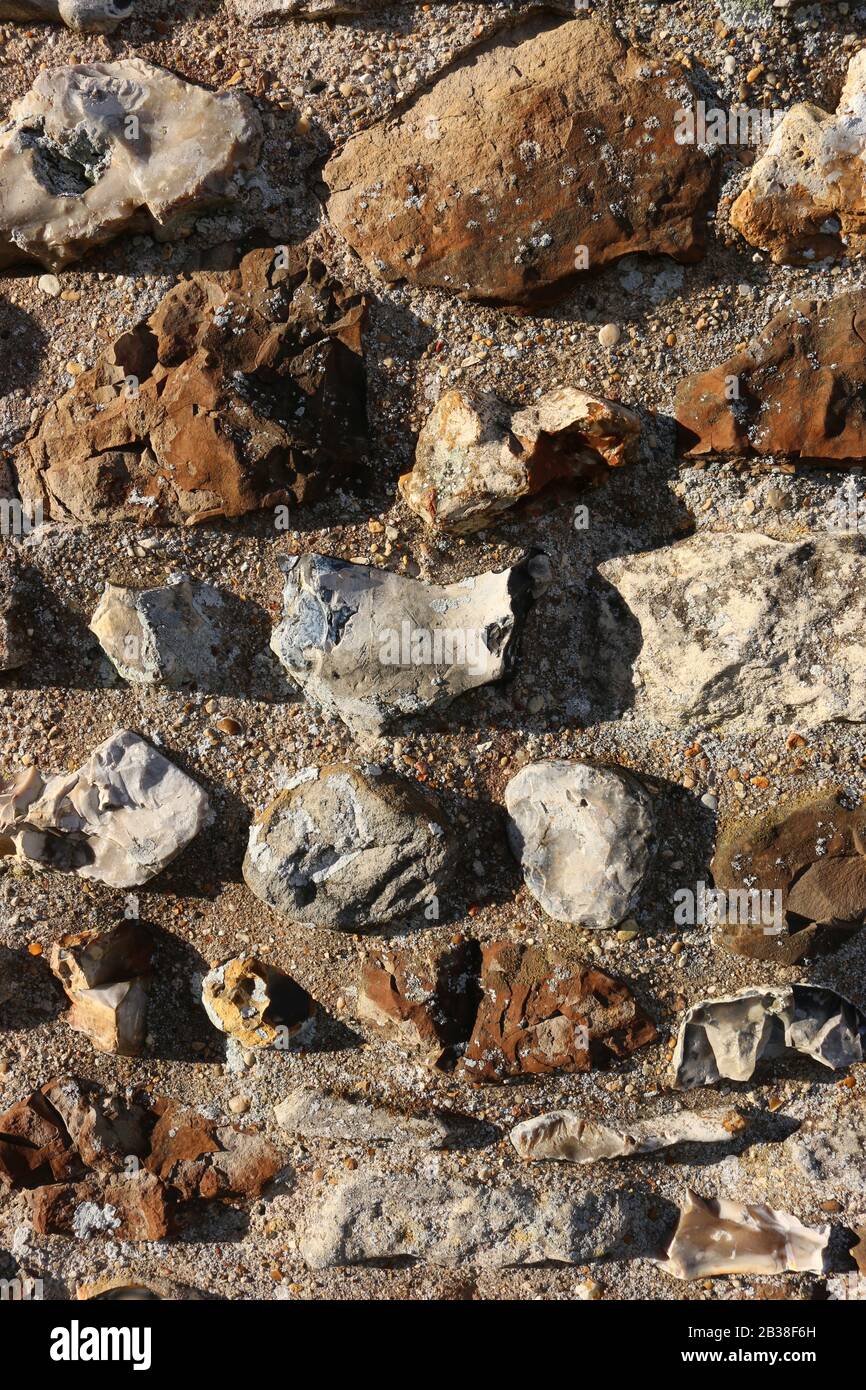 Old medieval castle wall in close up with flints and other stone set in ...
