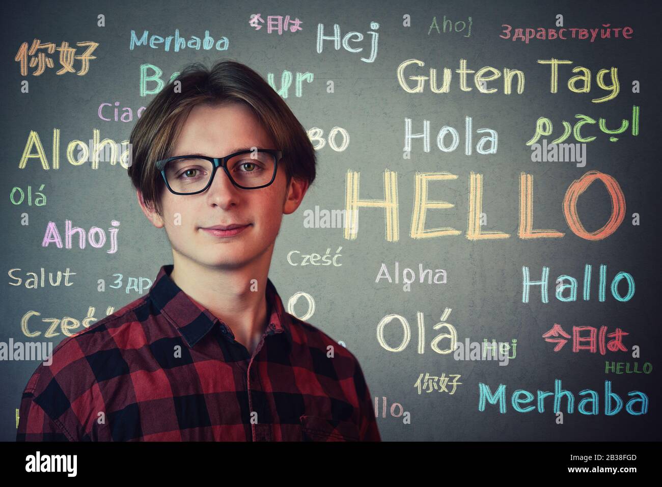 Positive teen guy wearing red shirt and eyeglasses over grey wall ...