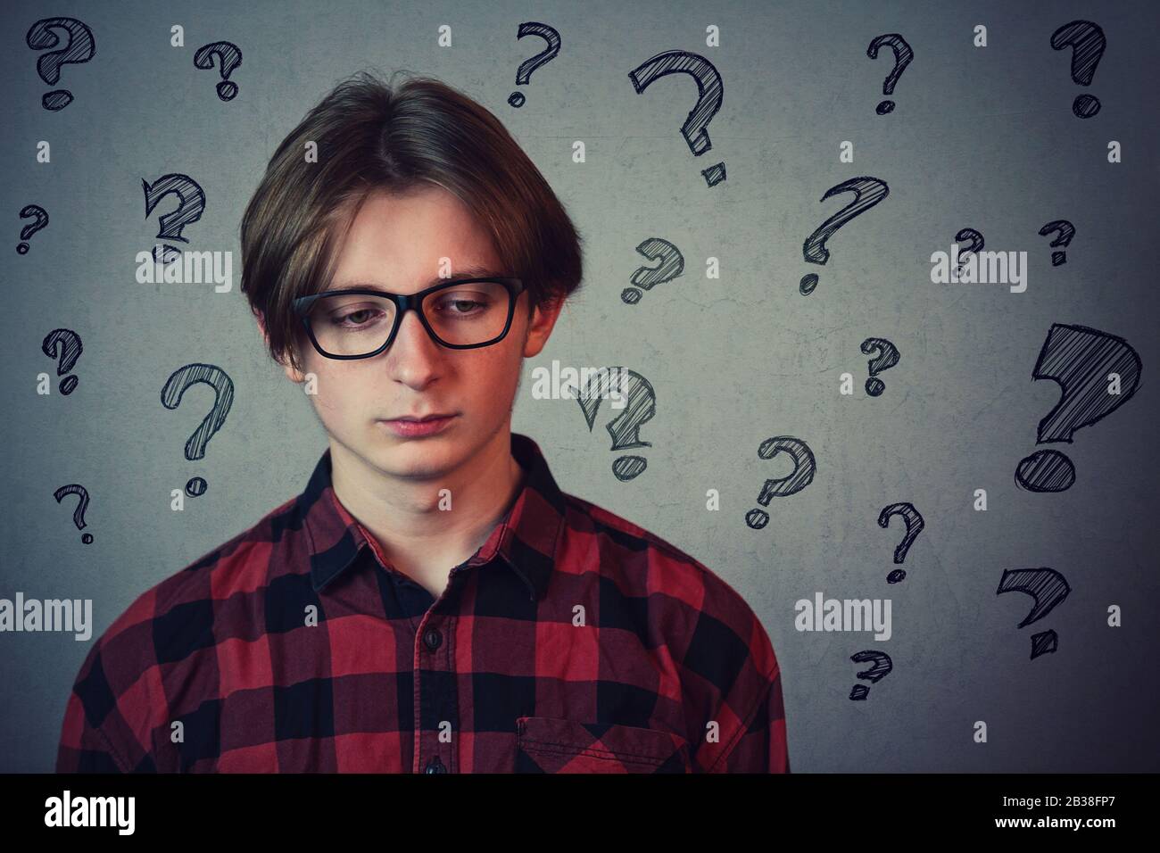 Sad and disappointed teenage boy, wearing red shirt and glasses ...
