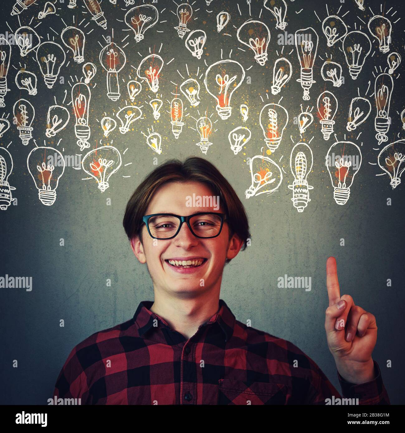 Joyful guy pointing index finger up, showing multiple light bulbs as ...