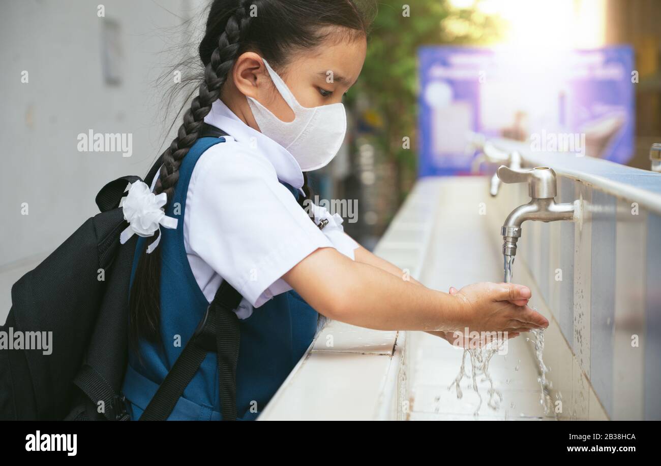 Asian student washing hands at the outdoor wash basin in the school ...