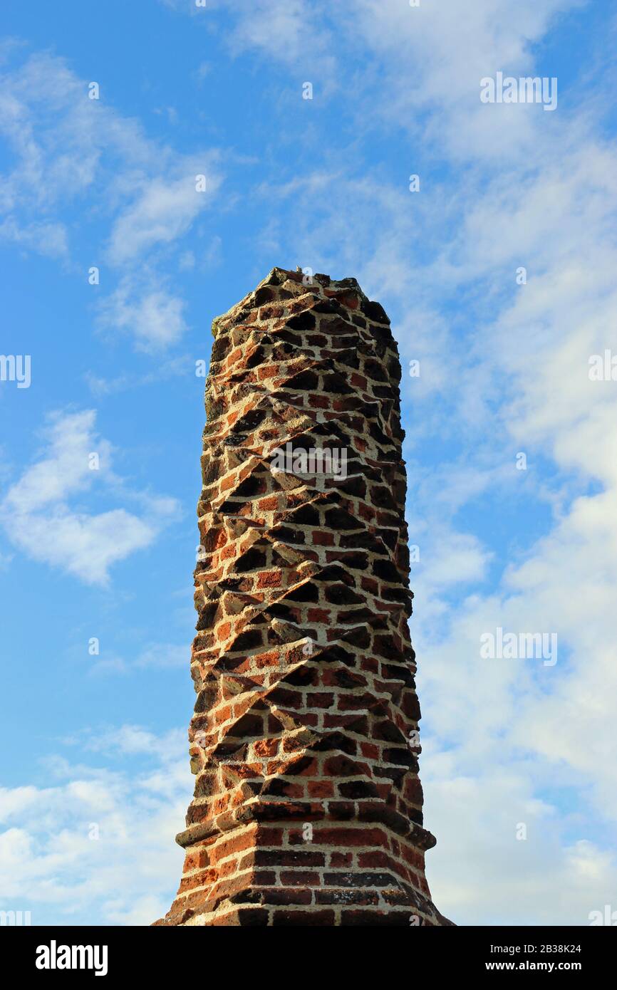 Tudor barley sugar twist red brick chimney pot with a blue sky with ...