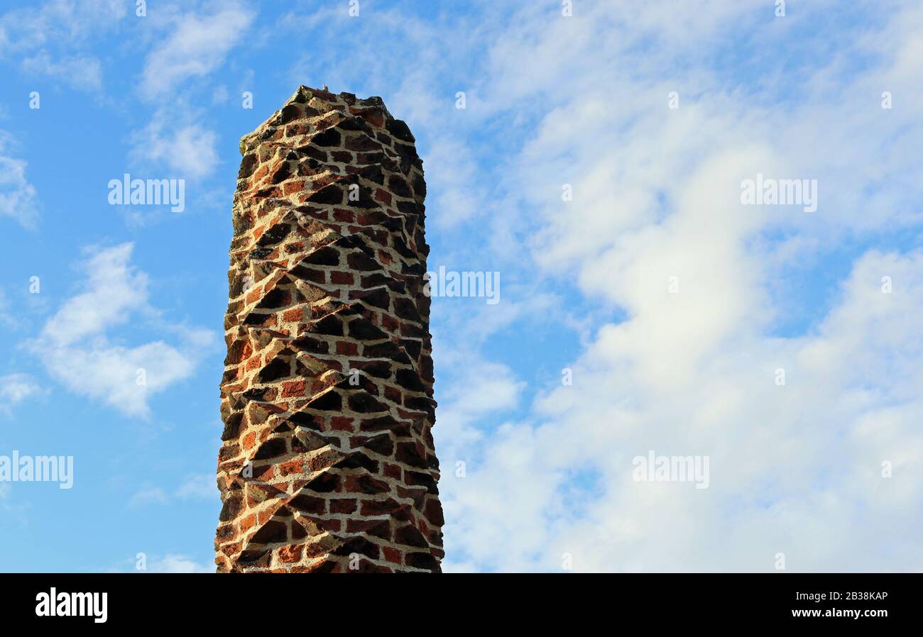 Tudor barley sugar twist red brick chimney pot with a blue sky with ...