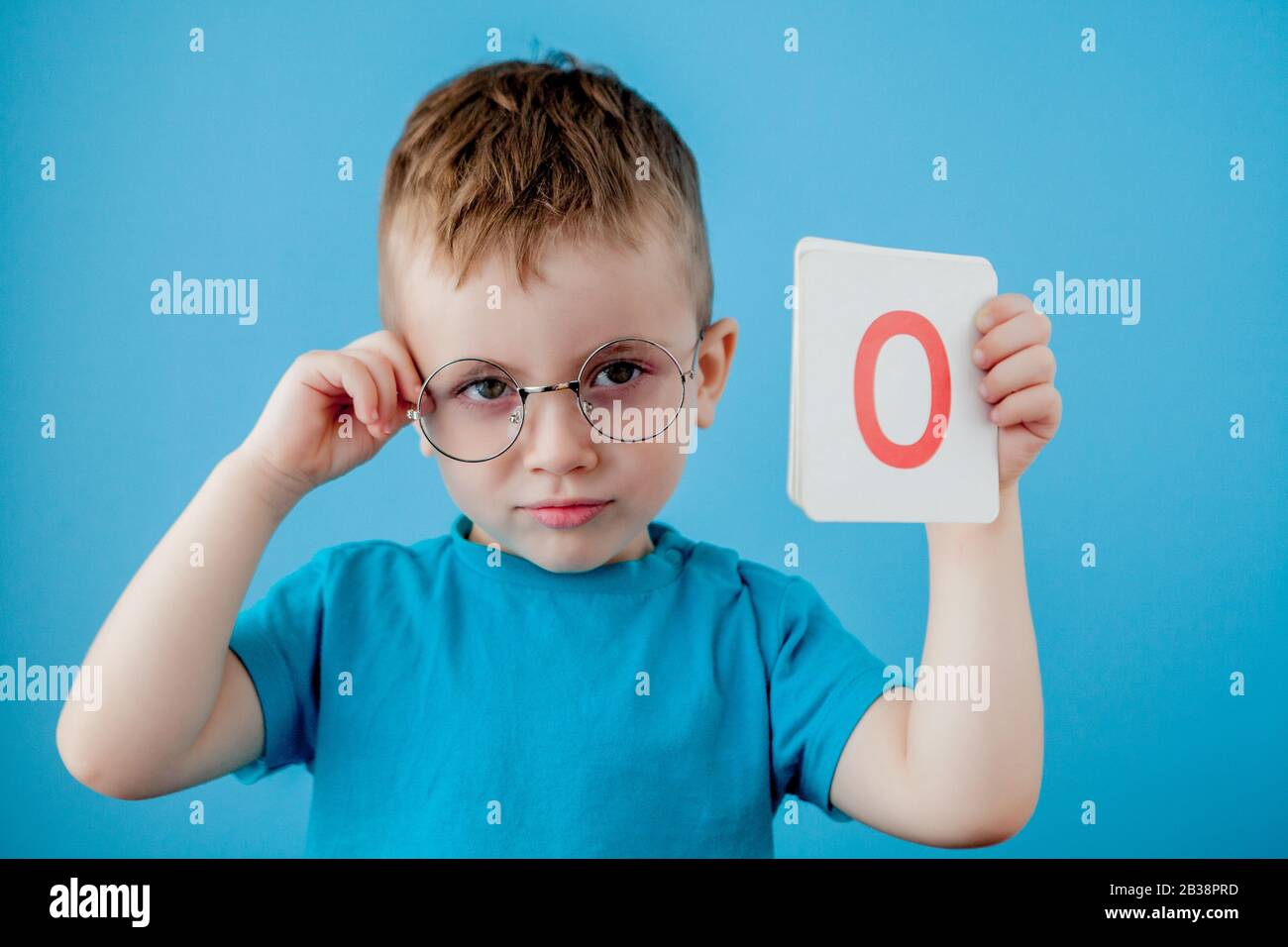 Cute little boy with letter on blue background. Child learning a ...