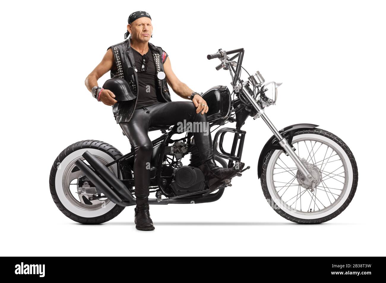 Biker holding a helmet and sitting on a custom chopper isolated on ...