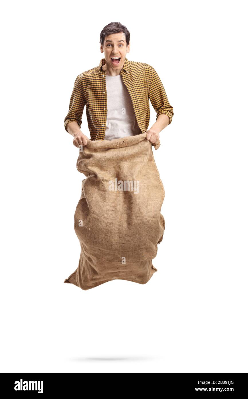 Excited young man playing a sack race isolated on white background ...