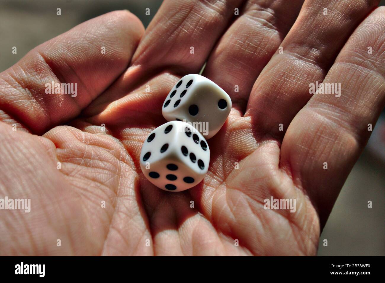 Man holding 2 black and white dice Stock Photo - Alamy