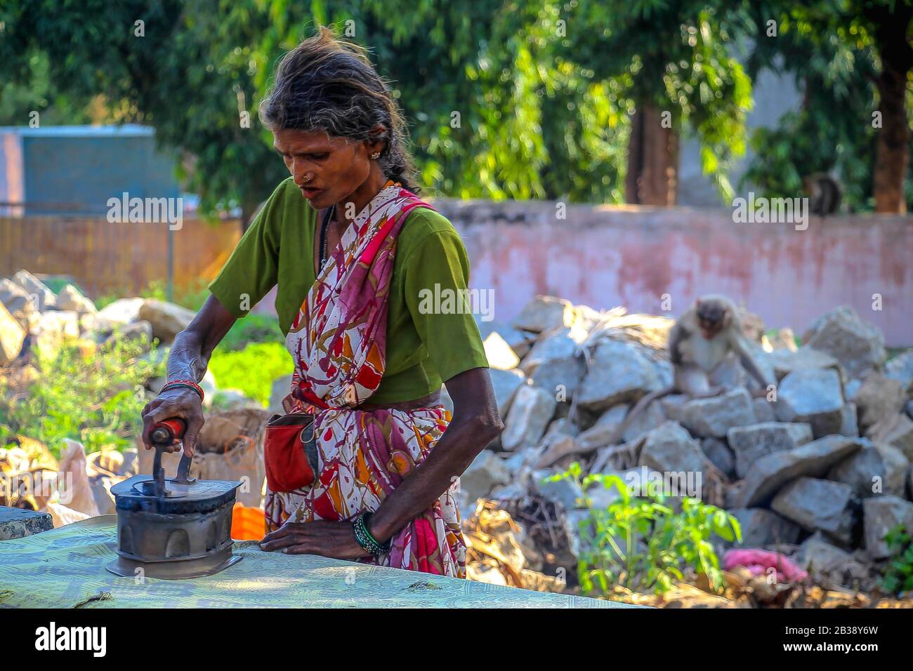 India - October 31, 2013: Woman ironing clothes in a street stall, in ...