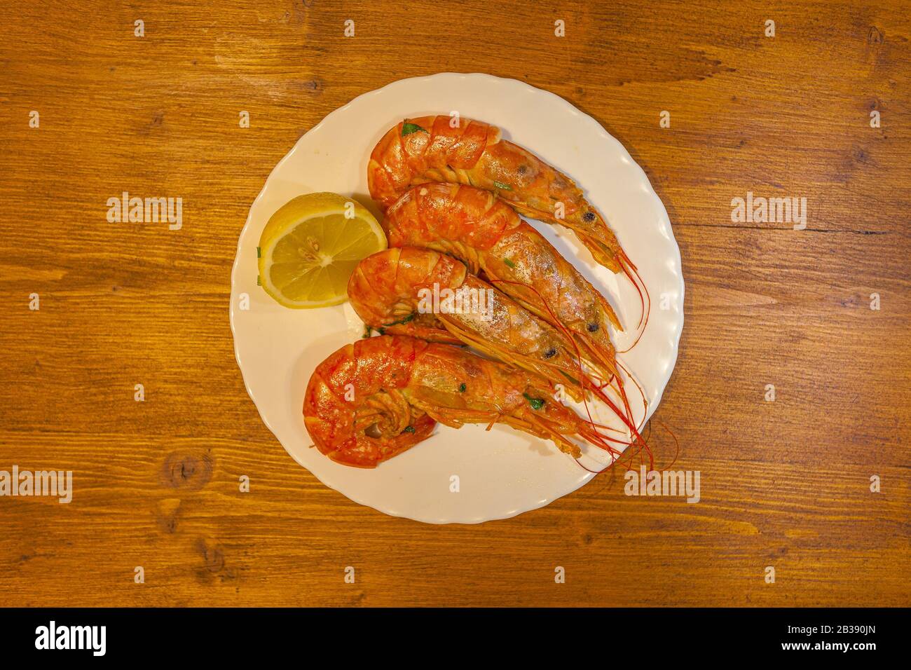 Cooked prawns with lemon on wooden background Stock Photo - Alamy