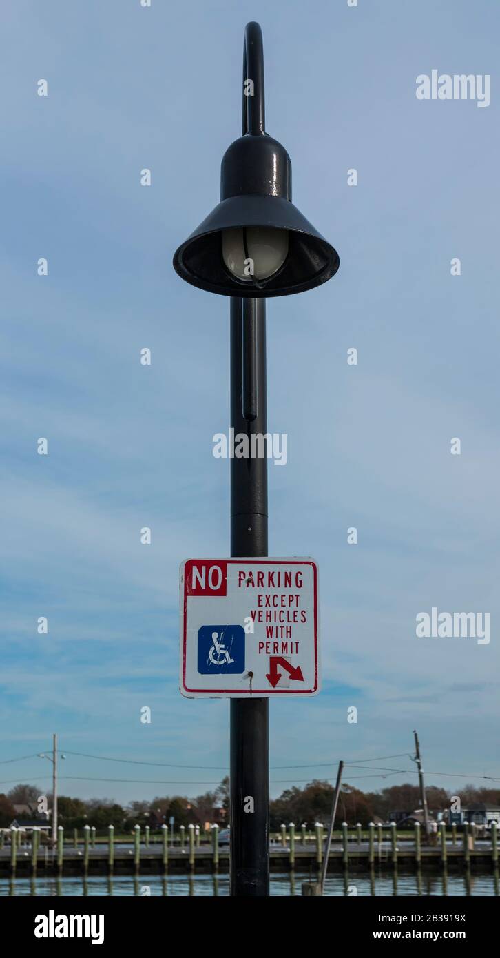 A lamp post at a local marina has a sign posted that reads, No Parking ...