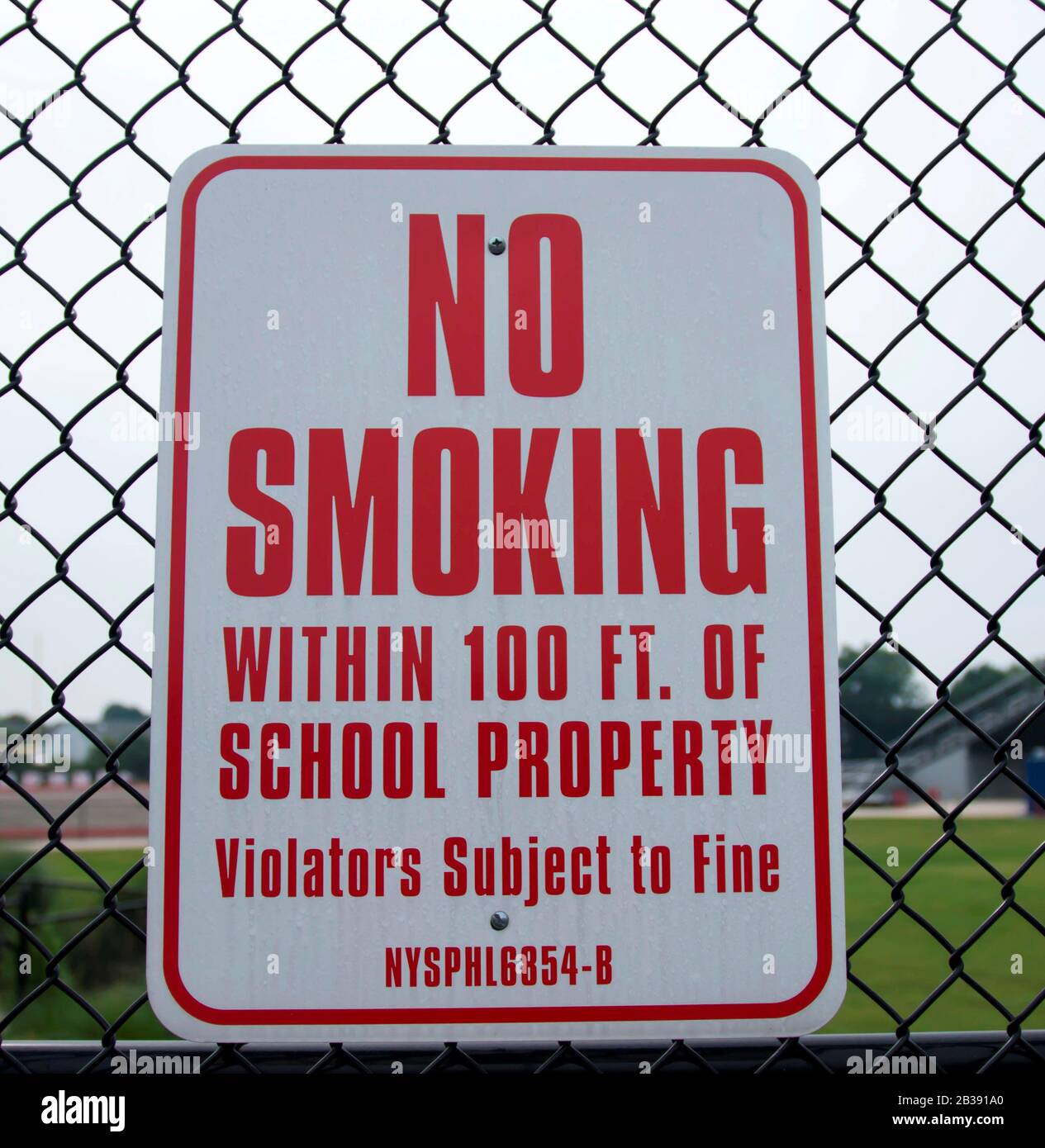 A no smoking sign hangs on a fence at a local high school Stock Photo ...