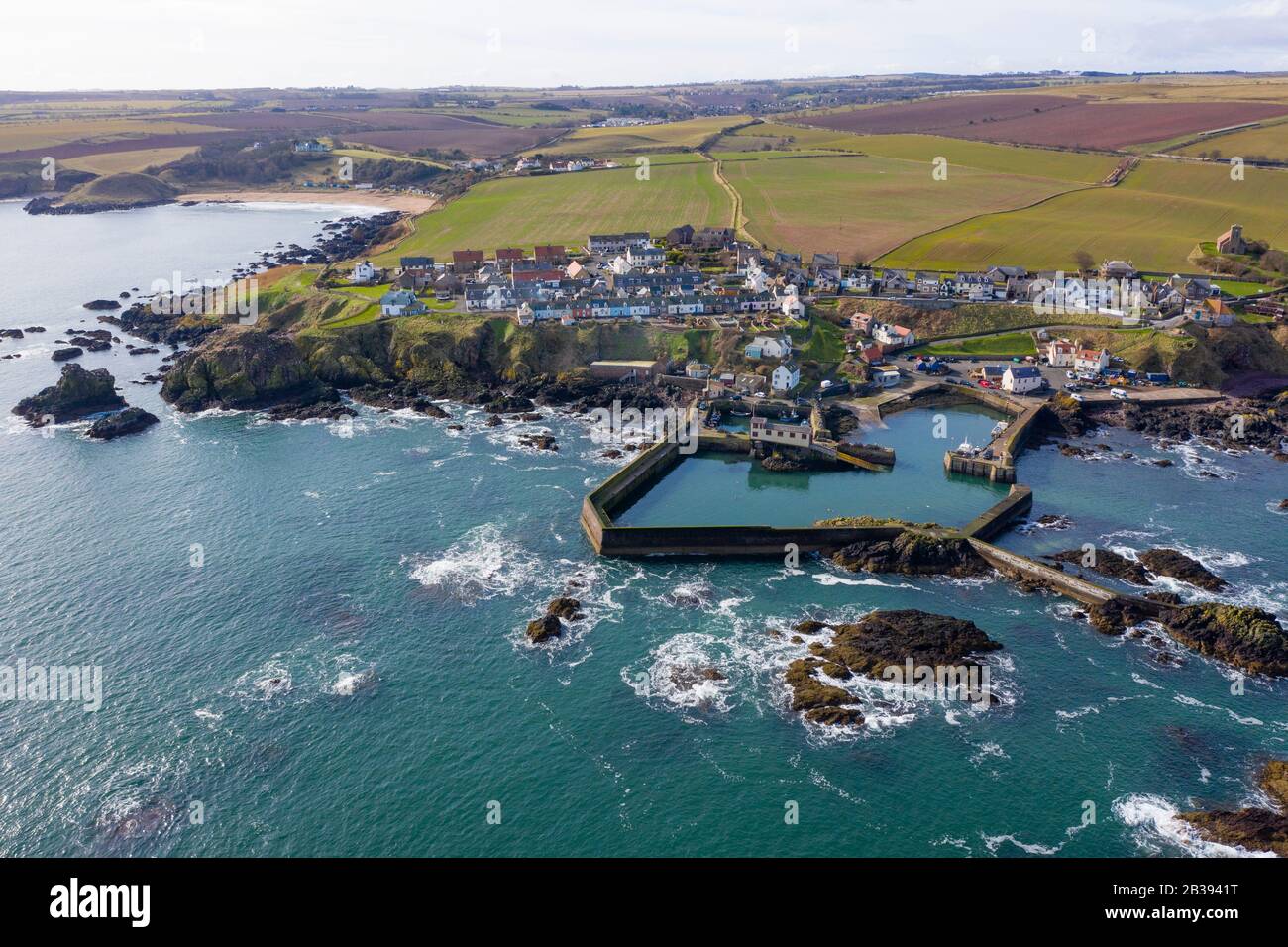 Aerial view of small fishing village and harbour of St Abbs on North ...
