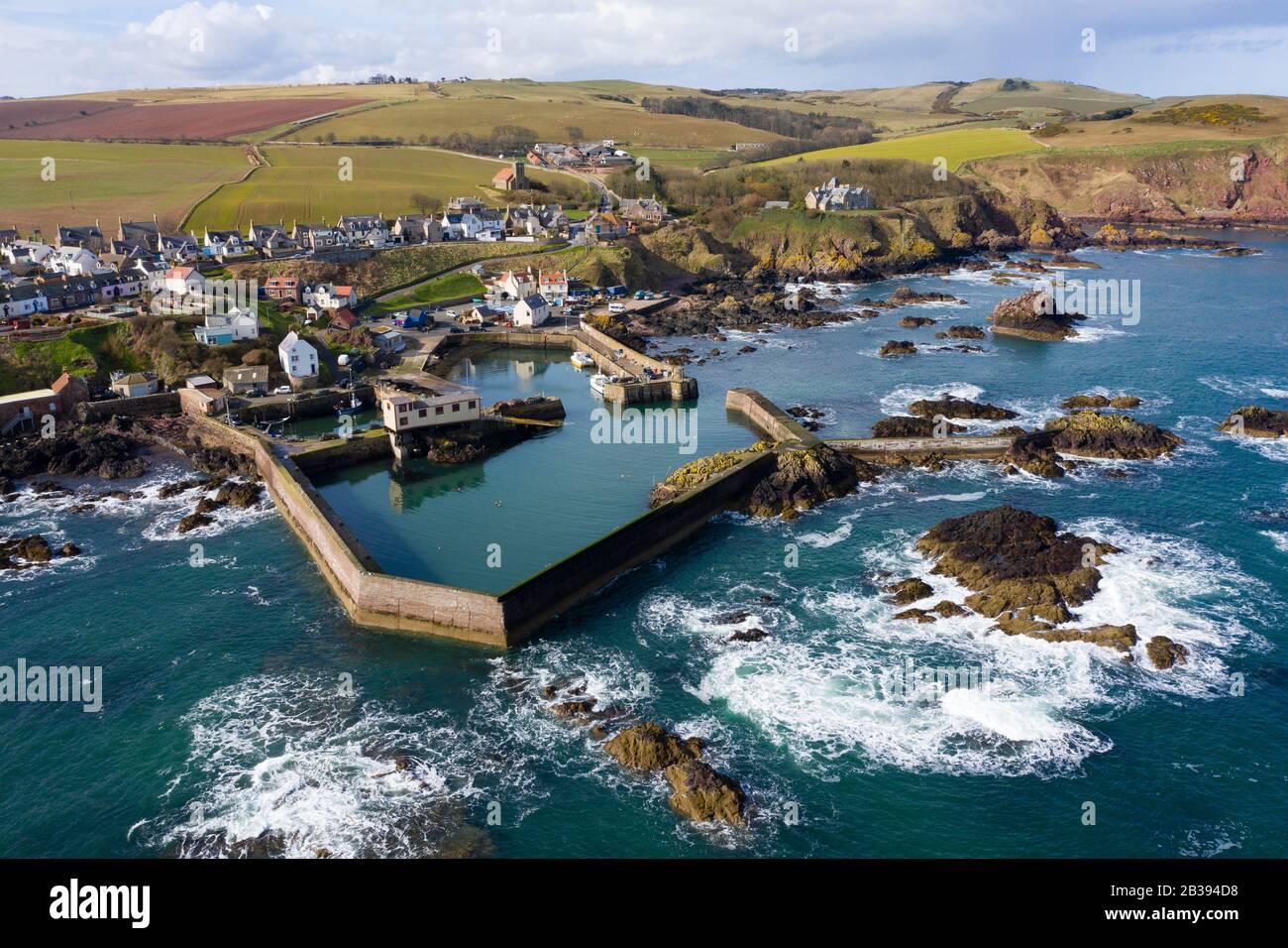 Aerial view of small fishing village and harbour of St Abbs on North ...