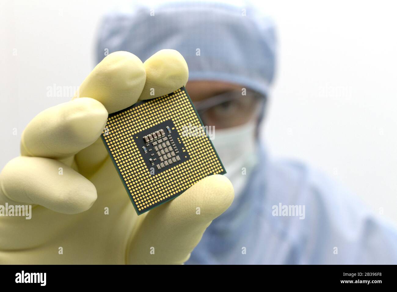 An engineer working in a clear room wearing a special uniform and ...