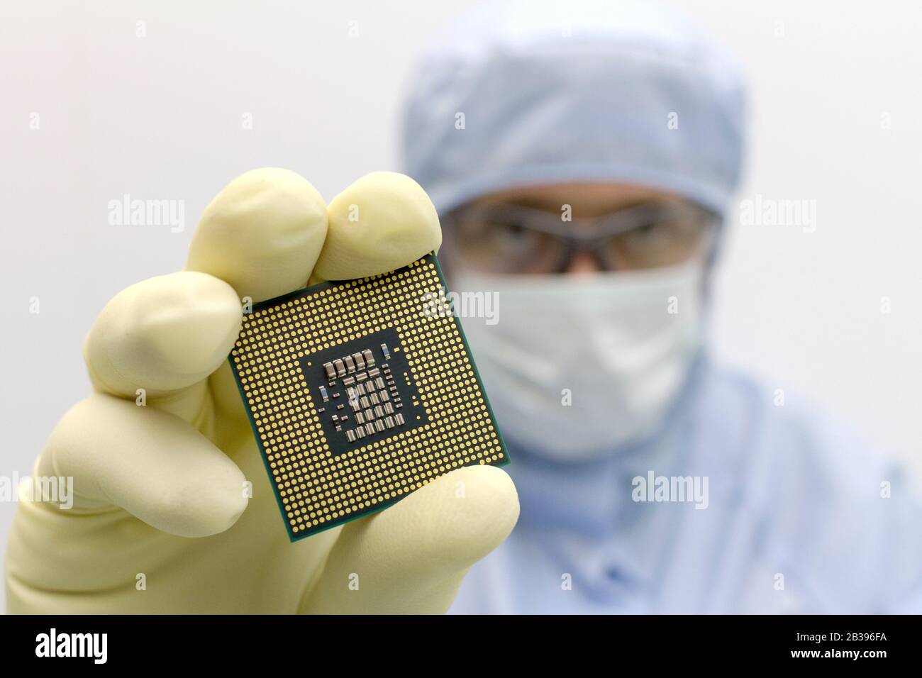 An engineer working in a clear room wearing a special uniform and ...