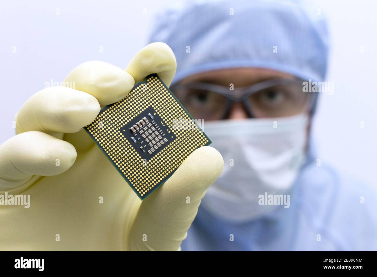 An engineer working in a clear room wearing a special uniform and ...