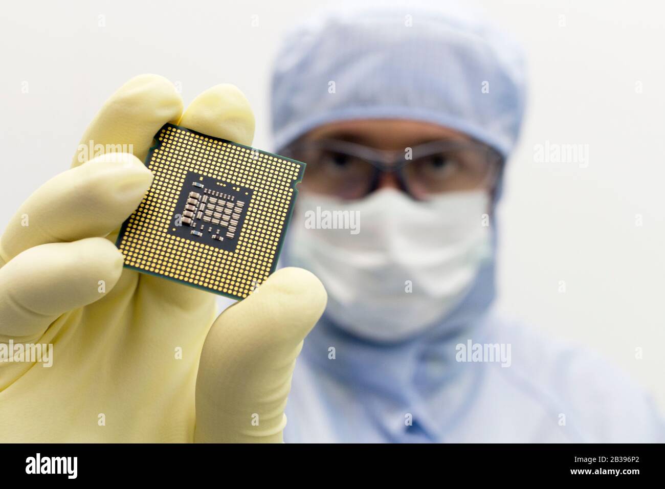 An engineer working in a clear room wearing a special uniform and ...