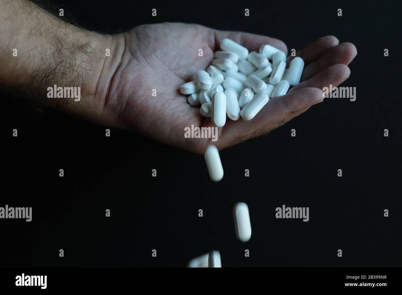 Medicine pills being thrown out by hand Stock Photo - Alamy