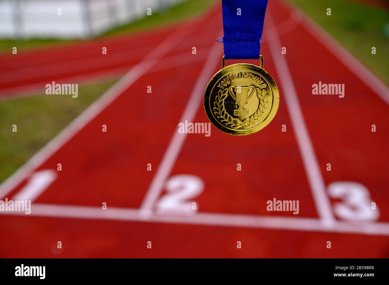 You are a winner, written on gold medal, athletics running track in ...