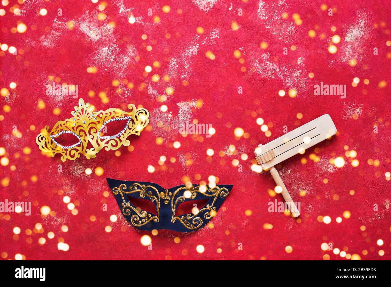 Red carnival background. Carnival mask and wooden gragger on bright red ...