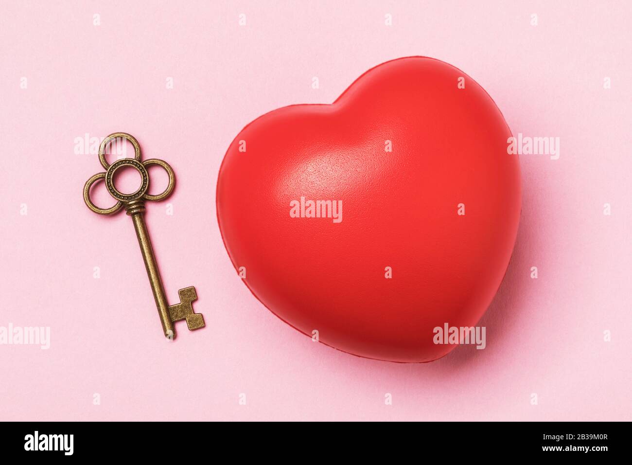 Key and heart on a pink background, top view. Relationship Theme Stock ...