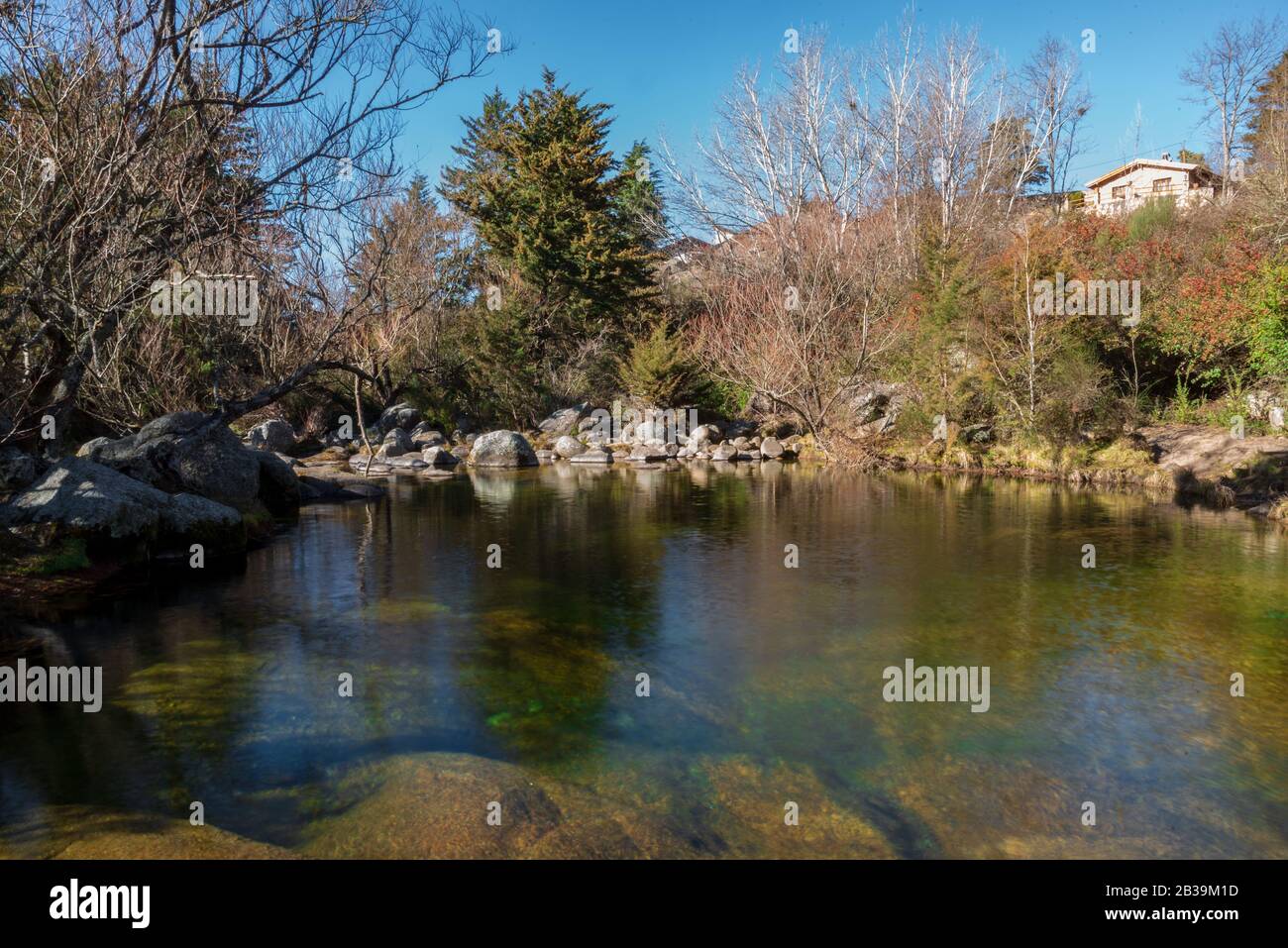 Panoramic view of a little lake down a valley, with a mountain full of ...