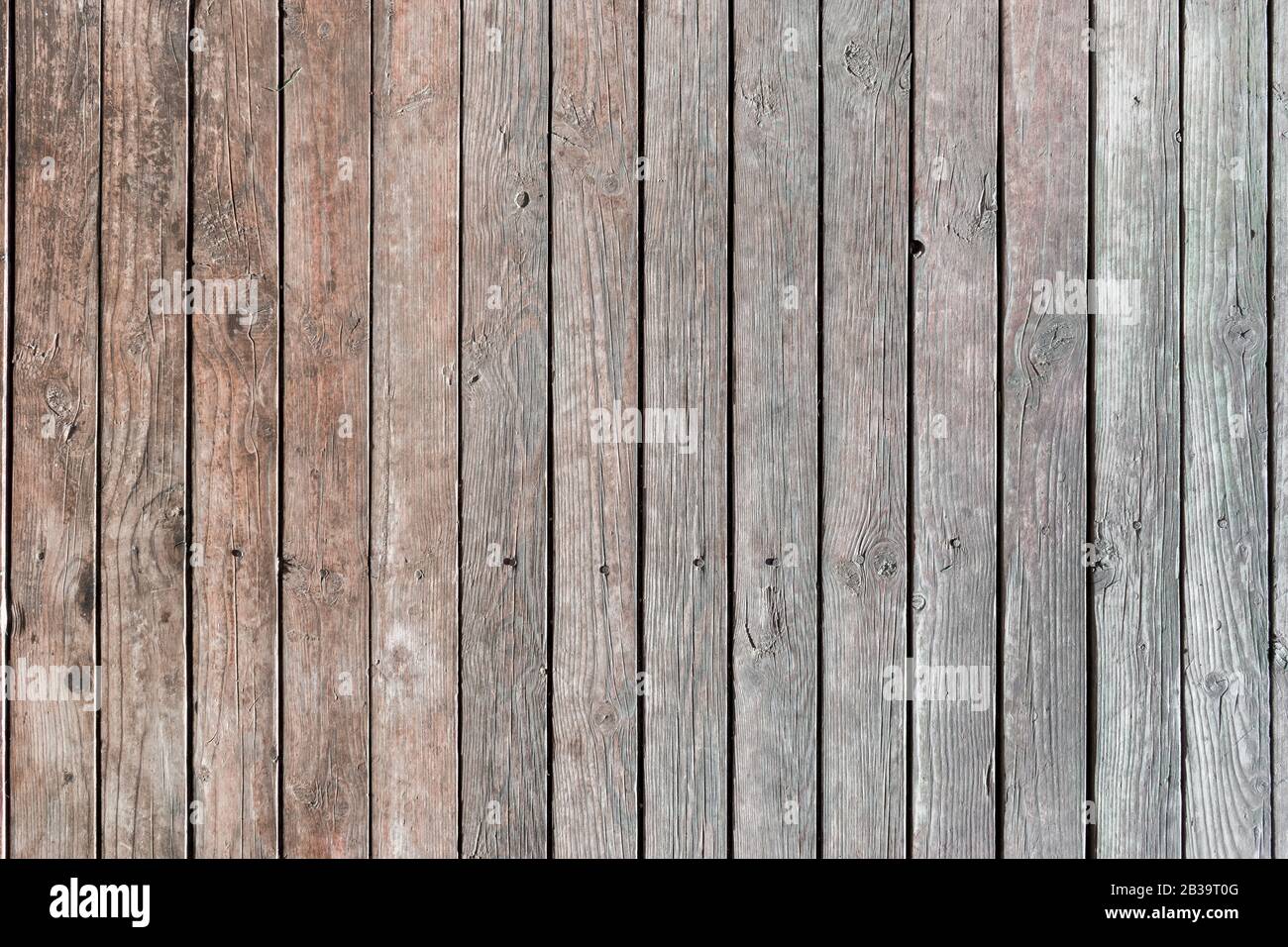 Close-up of narrow, cracked, weathered, rotten wooden planks driven in ...