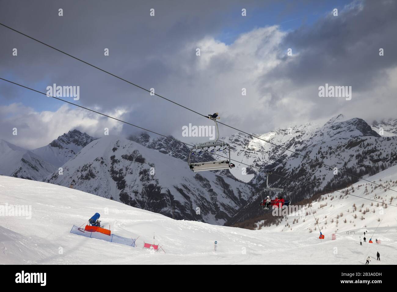Chair-lift, snowy ski track prepared by snowcat, skiers and ...