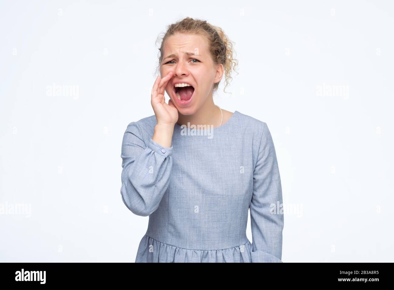 Young lovely curly woman screaming out loud, isolated on a white ...