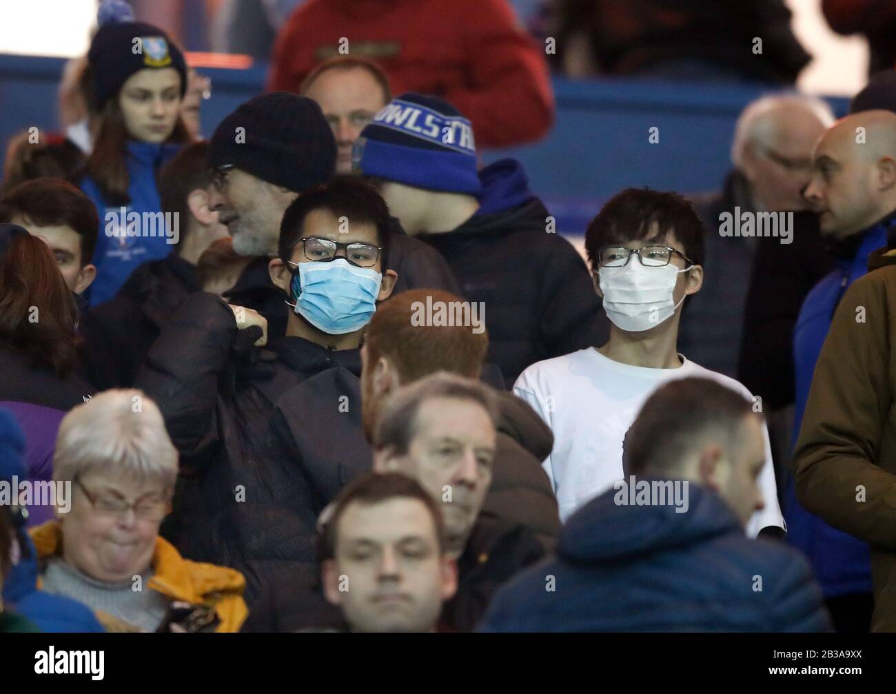 Fans wearing protective masks in the stands to prevent the spread of ...