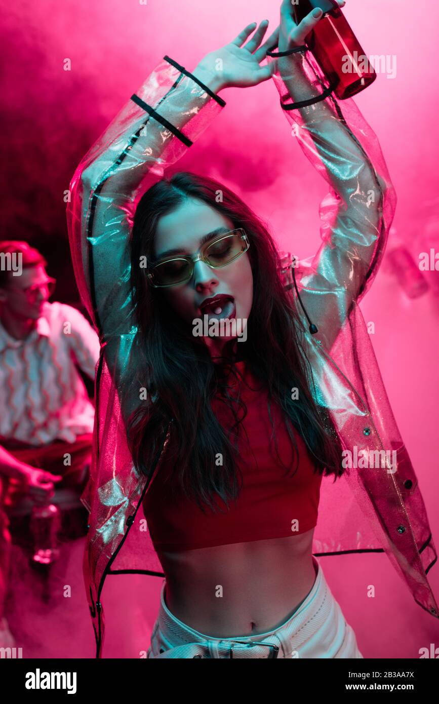 beautiful girl in sunglasses with lsd on tongue dancing in nightclub ...