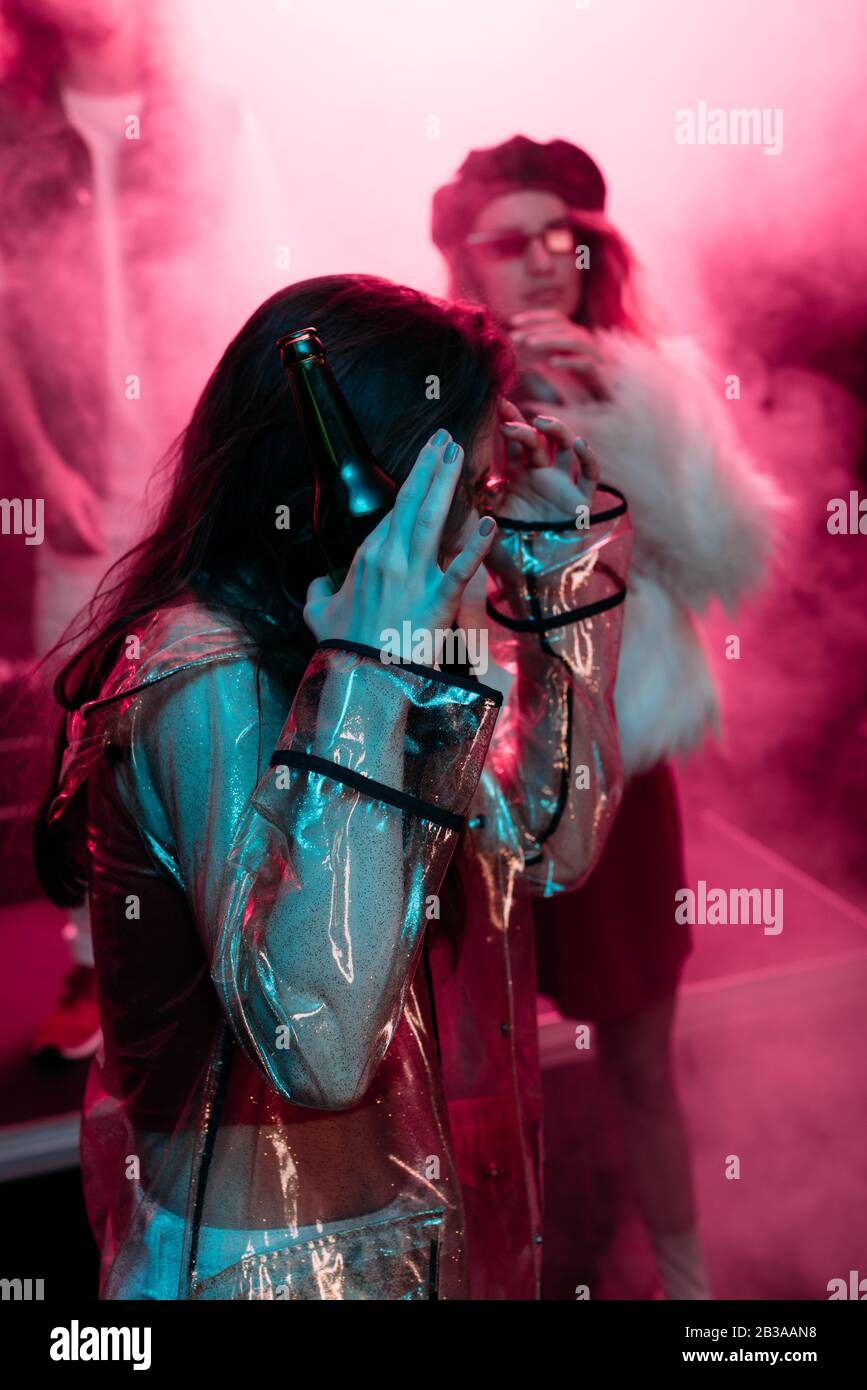 girl covering face while dancing in nightclub with pink smoke Stock ...